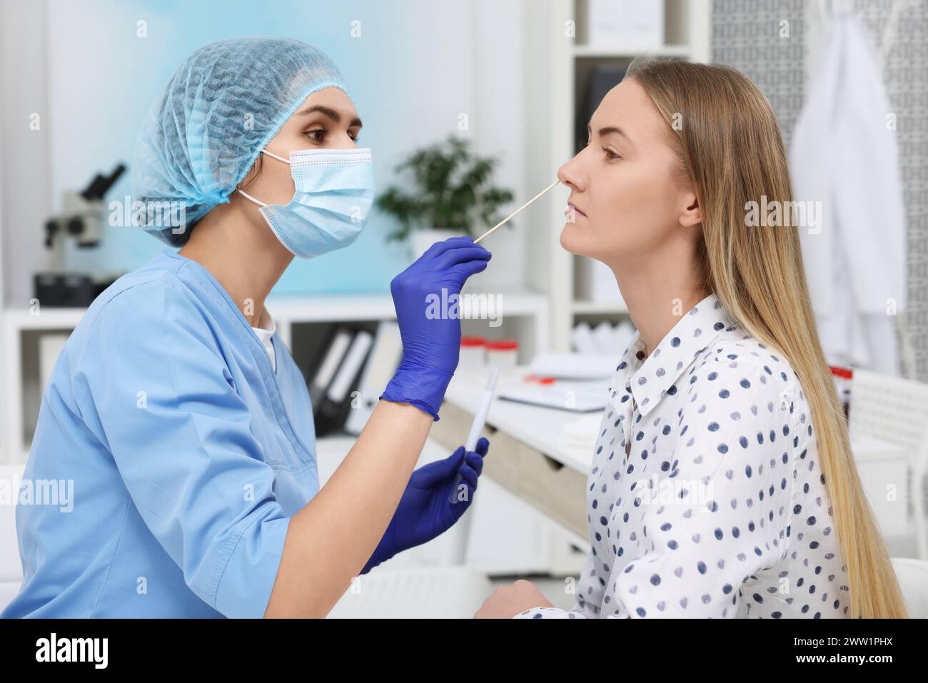 Laboratory testing. Doctor taking sample from patient's nose with ...