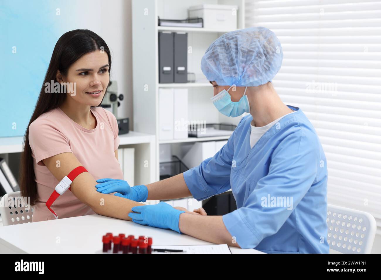 Laboratory testing. Doctor taking blood sample from patient at white ...