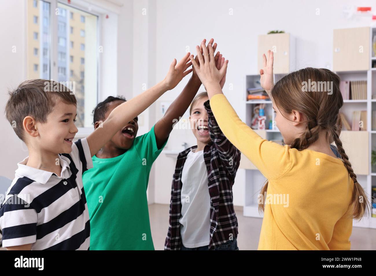 Happy children giving high five at school Stock Photo - Alamy