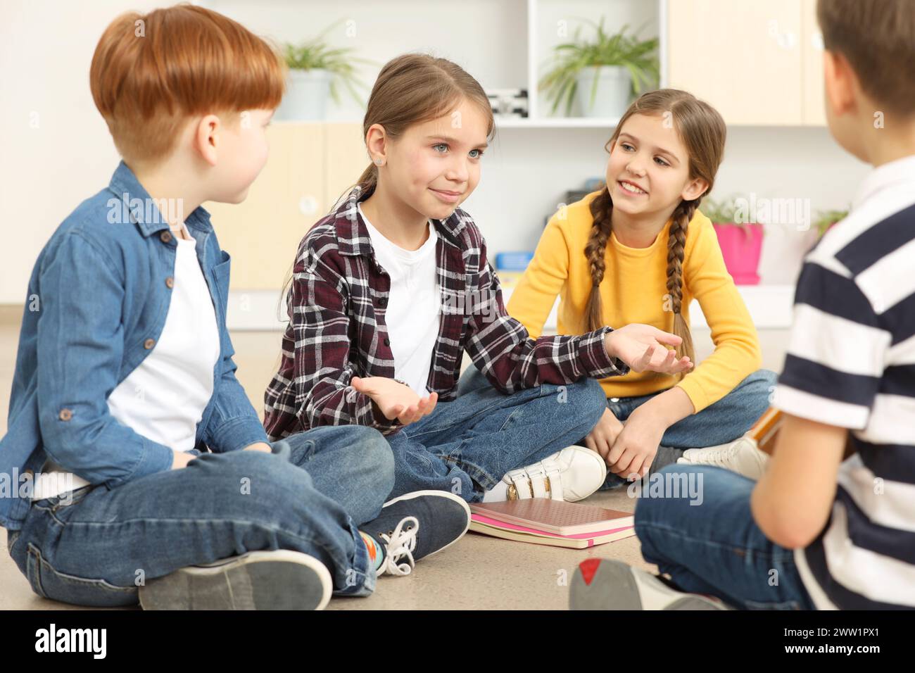 Cute children discussing in classroom at school Stock Photo - Alamy