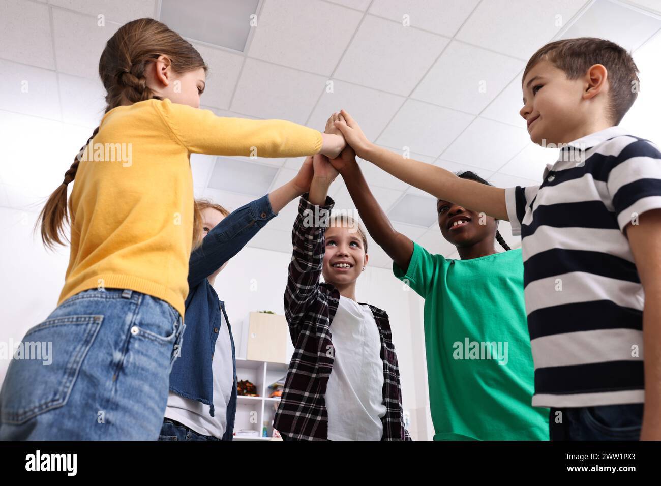 Happy children giving high five at school, low angle view Stock Photo ...
