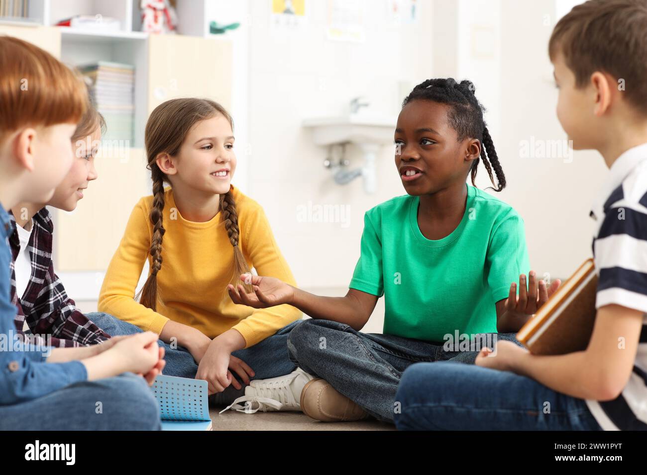 Cute children discussing in classroom at school Stock Photo - Alamy