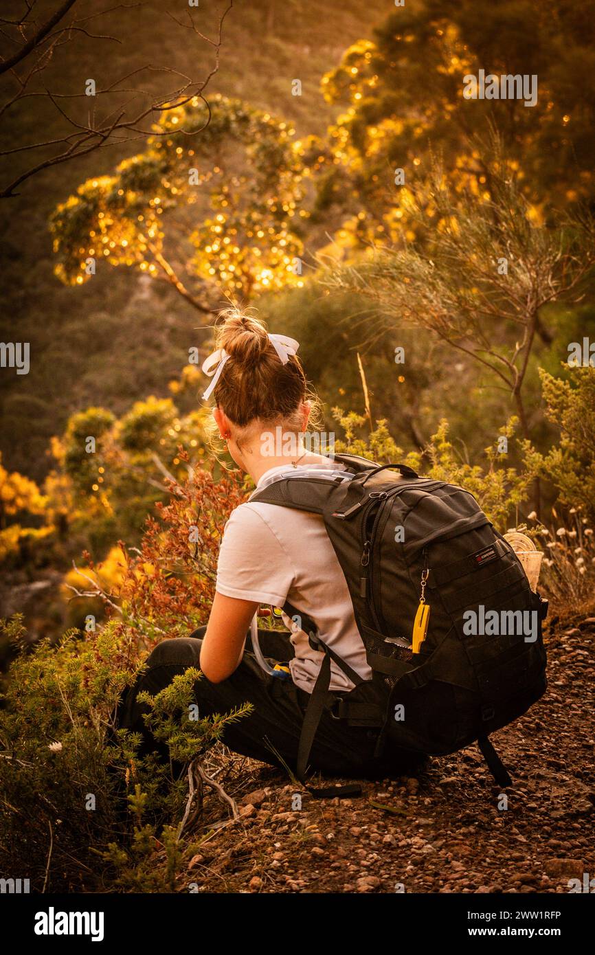A hiker finds peace while resting on a secluded trail at dusk Stock ...