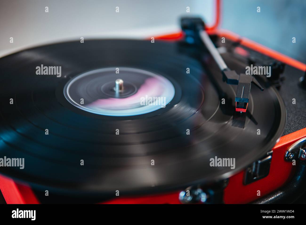 Vinyl record spinning on a red turntable, symbolizing classic home ...
