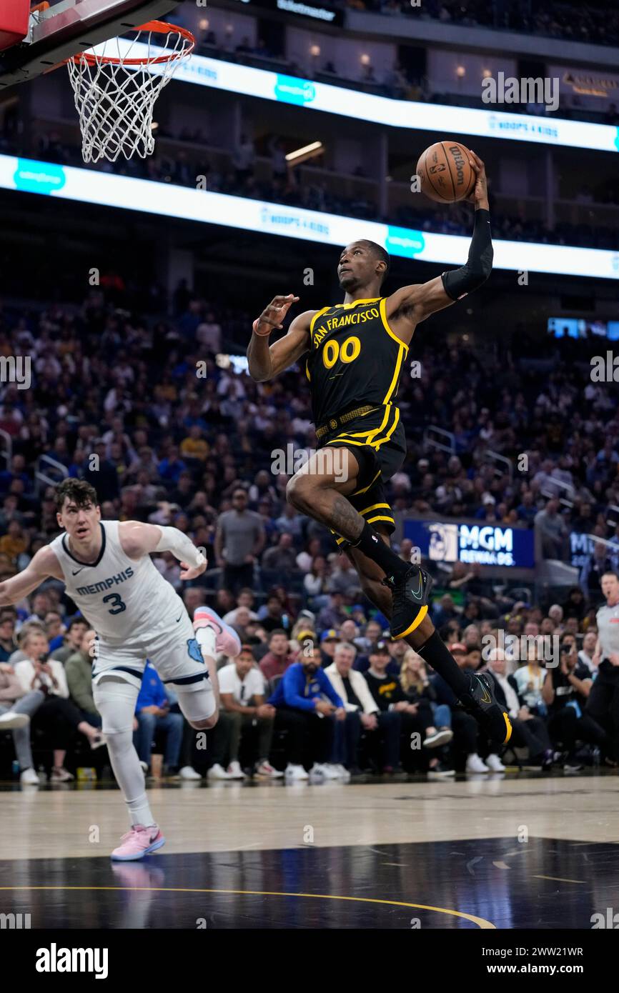 Golden State Warriors forward Jonathan Kuminga, right, dunks next to ...