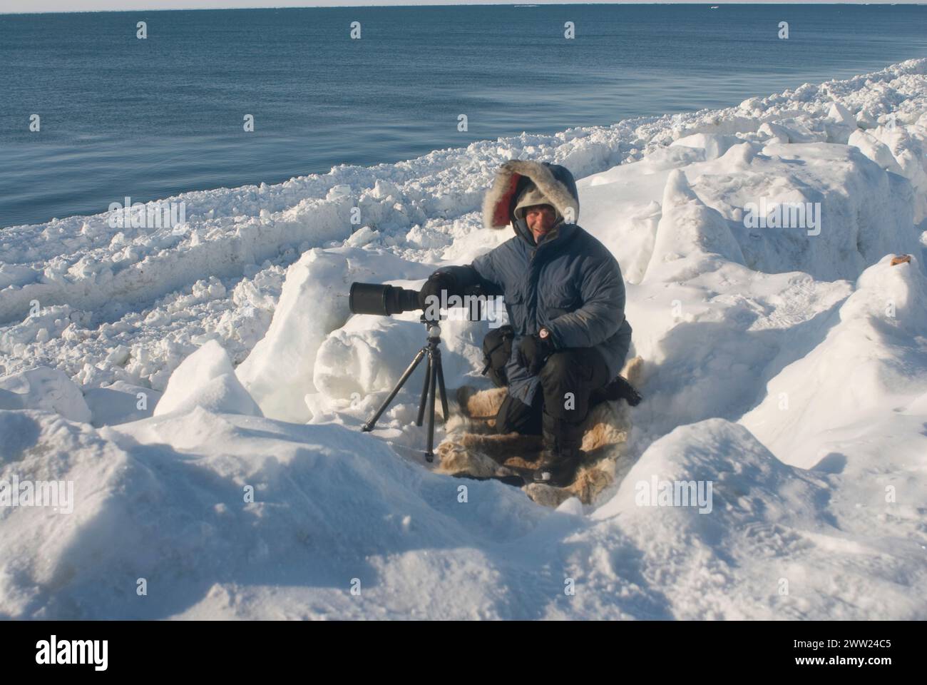 Photographer Steven Kazlowski with camera, tripod at the edge of an ...