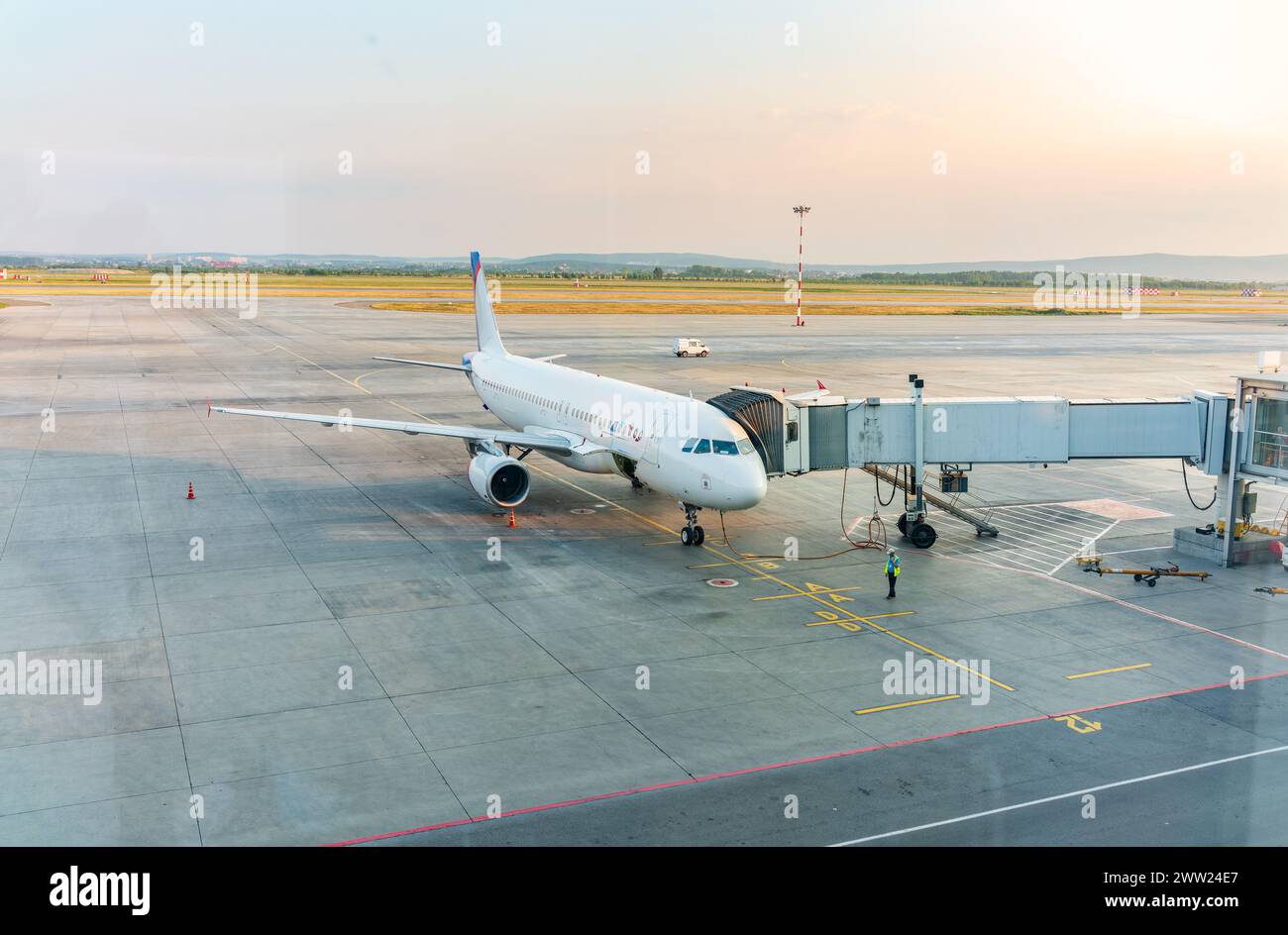 Passenger plane on the airfield connected to walkway.The gate sleeve is ...