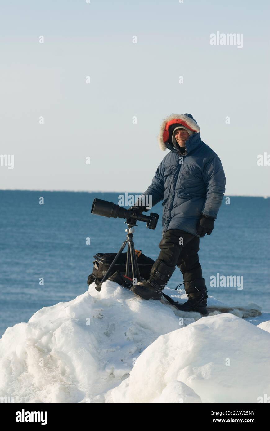 Photographer Steven Kazlowski with camera, tripod at the edge of an ...