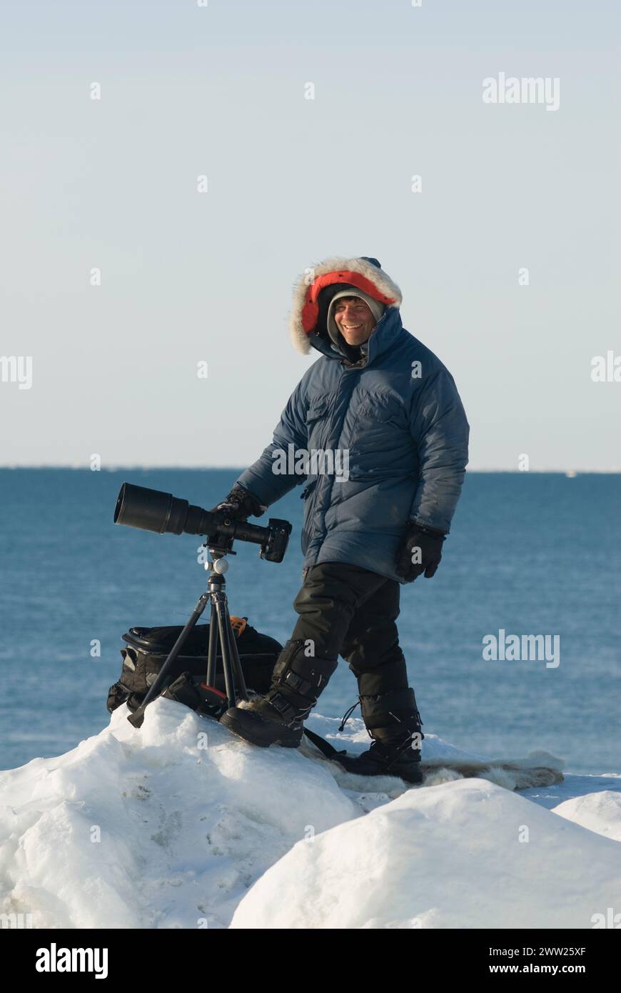 Photographer Steven Kazlowski with camera, tripod at the edge of an ...