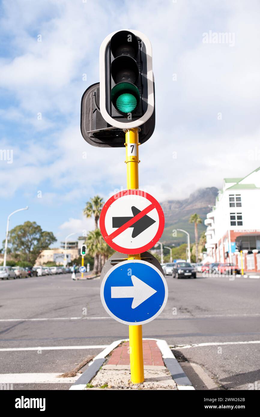 Road sign, traffic light and signage in street for direction with ...