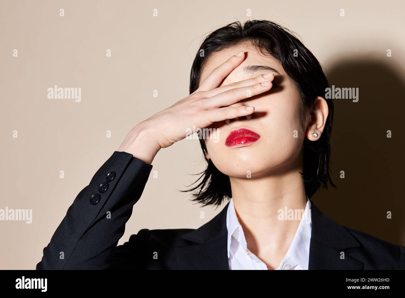 A woman covering her eyes with her hand Stock Photo - Alamy