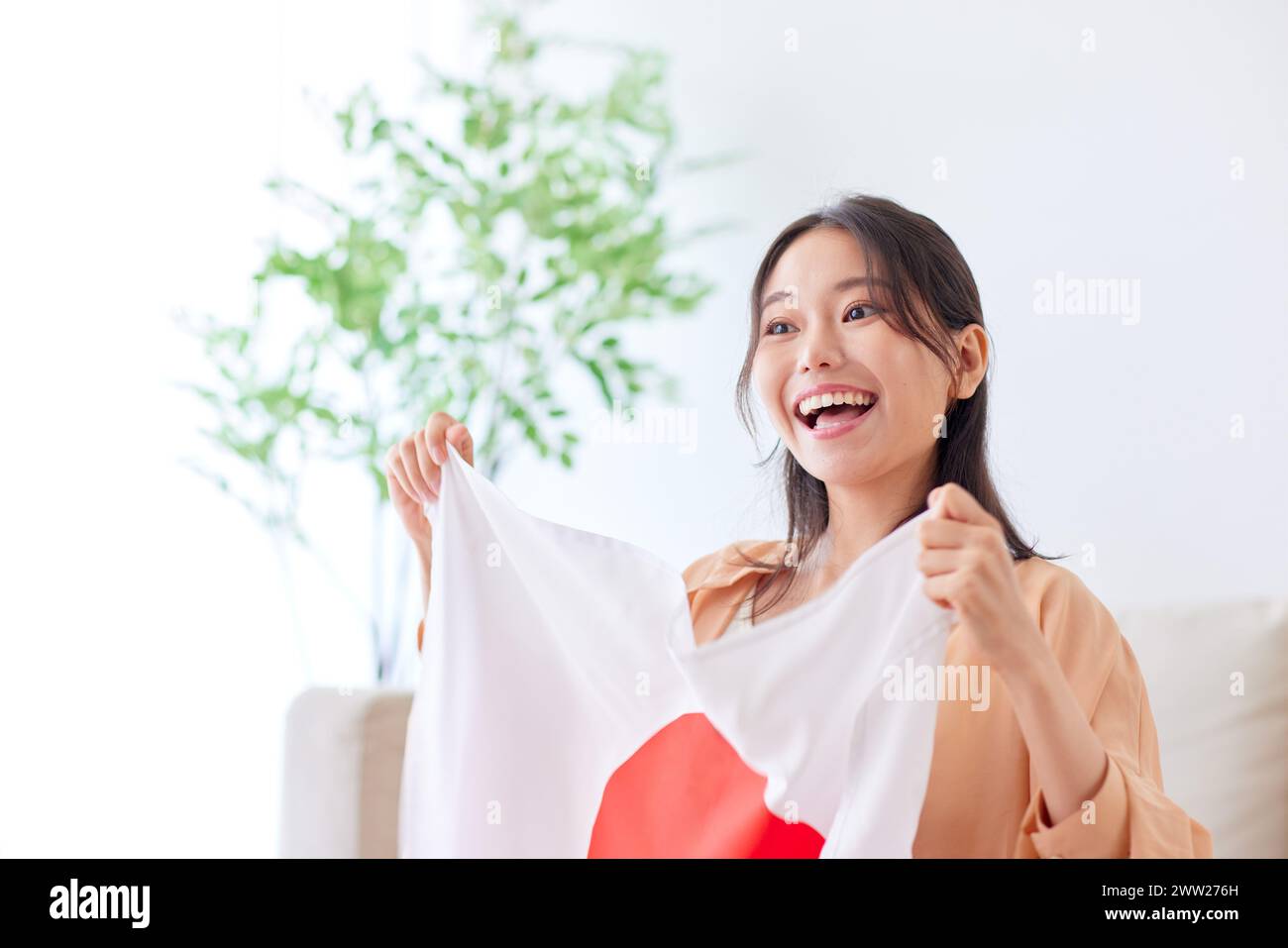 A woman holding up a Japanese flag Stock Photo - Alamy