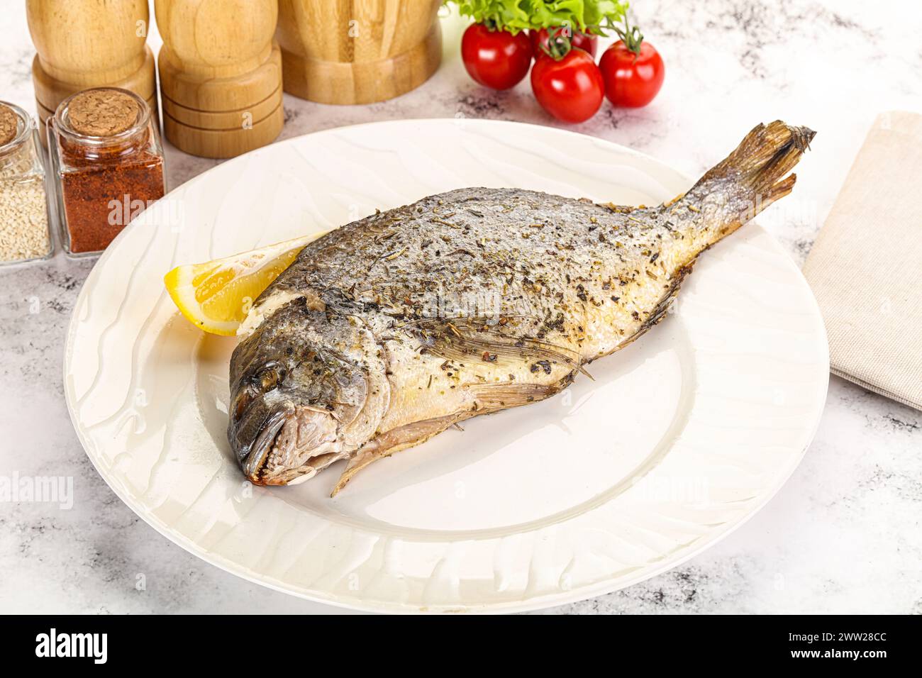 Baked Dorado fish served lemon slice Stock Photo - Alamy