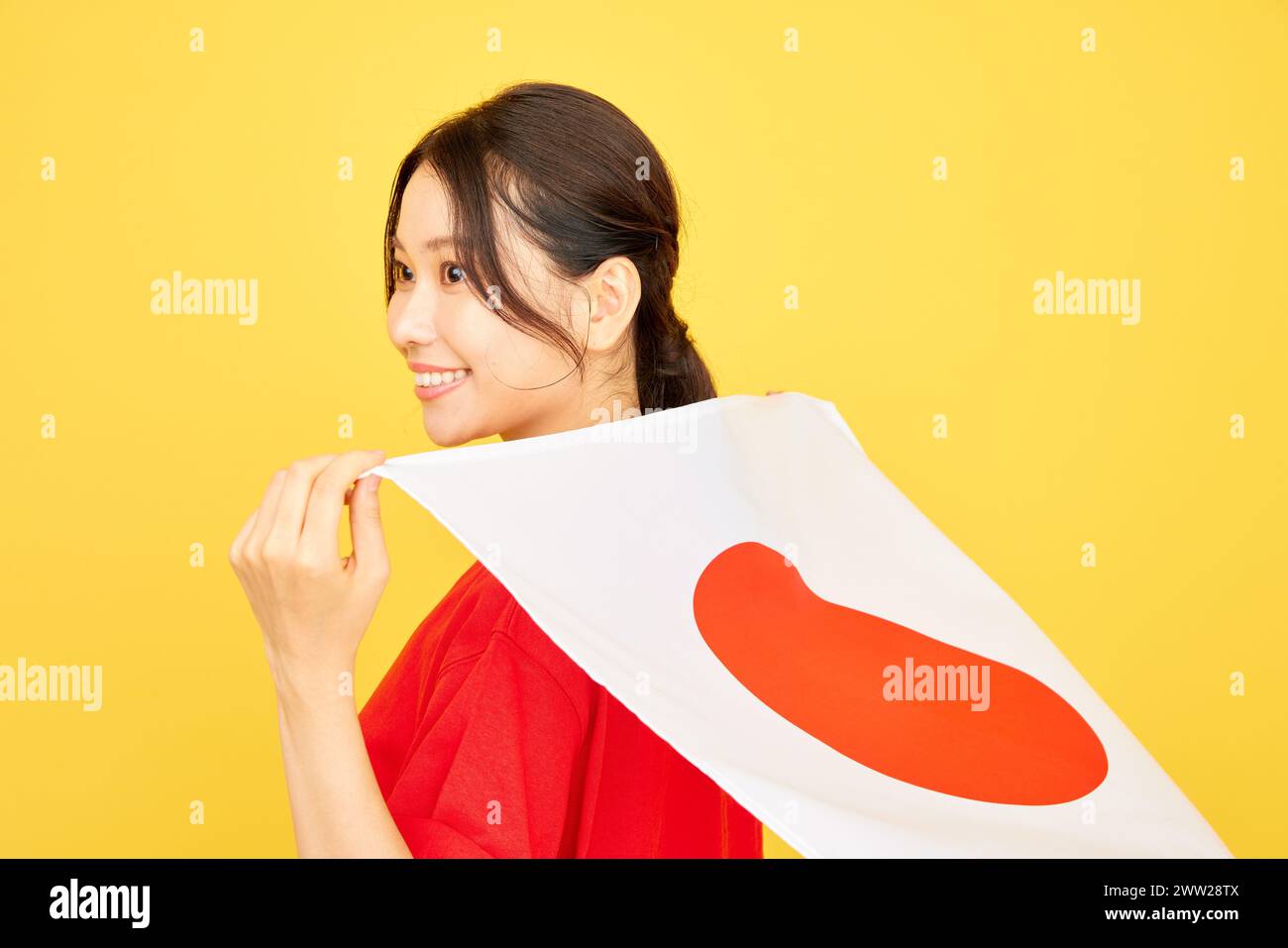 Asian woman holding Japan flag over yellow background Stock Photo - Alamy