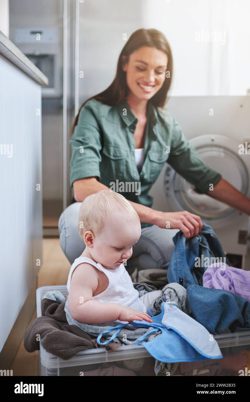 Laundry, washing and mother with baby in home for multitasking ...