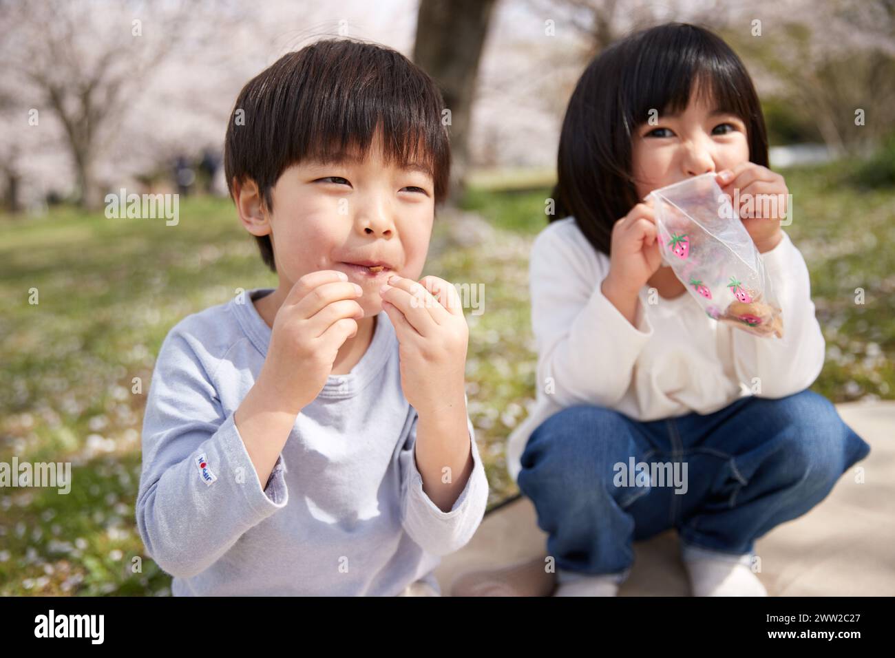 Two children sitting on the ground Stock Photo - Alamy