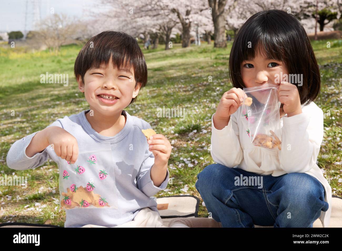 Two children sitting on the ground Stock Photo - Alamy