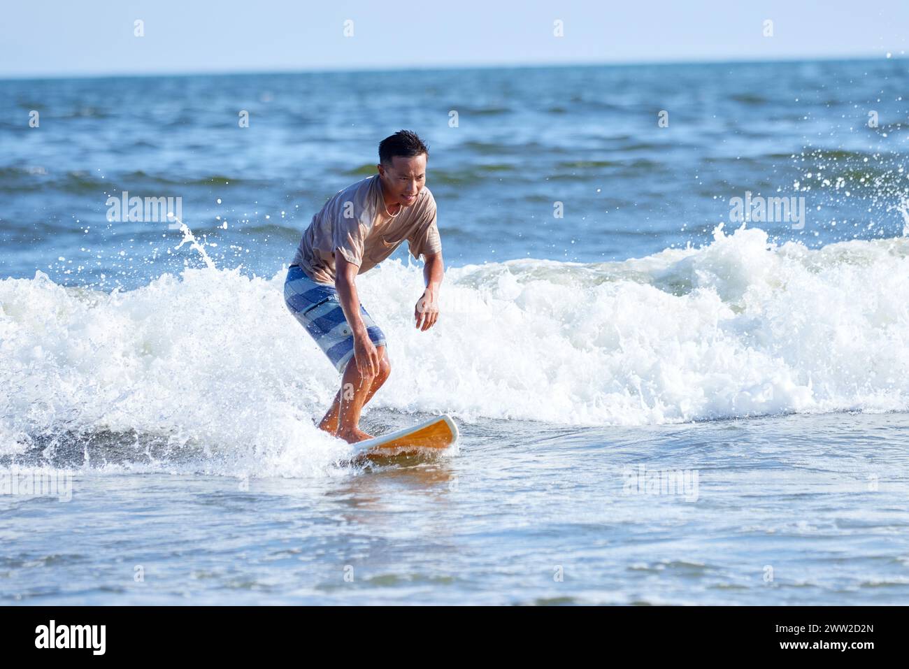 A man riding a surfboard in the ocean Stock Photo - Alamy