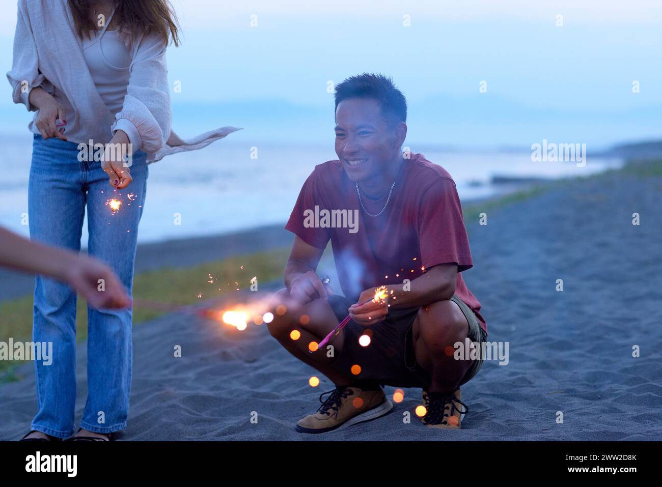 Sitting on beach woman holding hi-res stock photography and images - Alamy