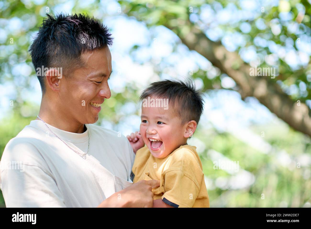 A man holding a child in his arms Stock Photo - Alamy