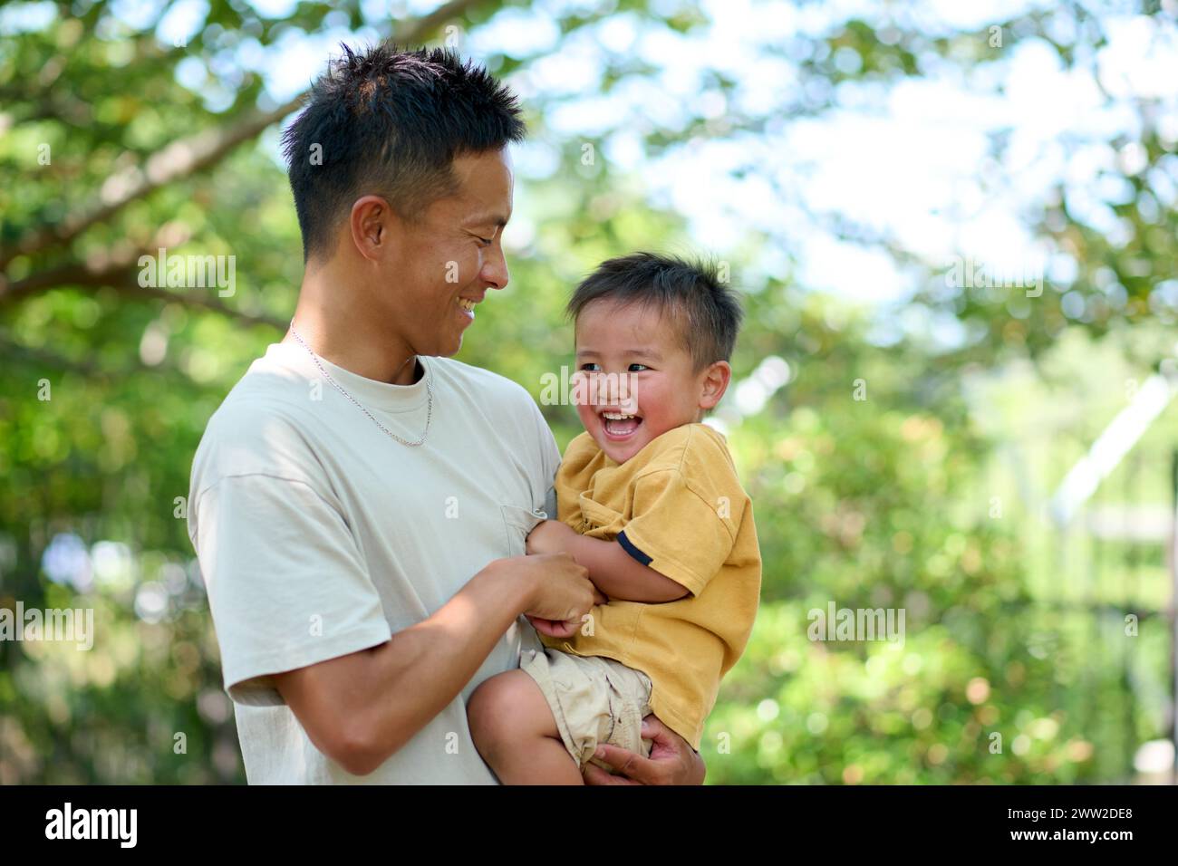 A man holding a child in his arms Stock Photo - Alamy