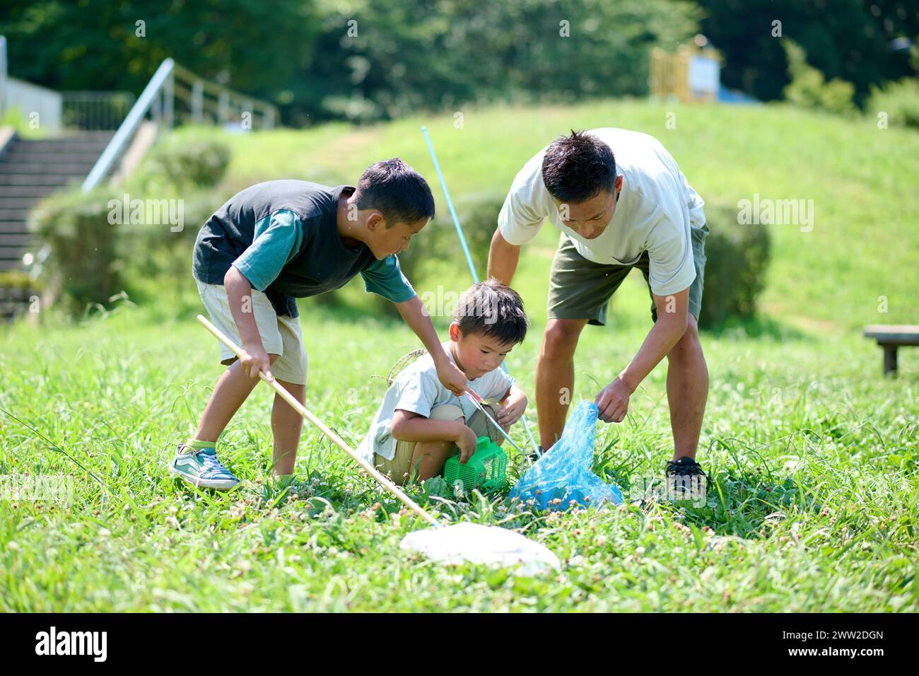 A man and kids playing in the grass Stock Photo - Alamy