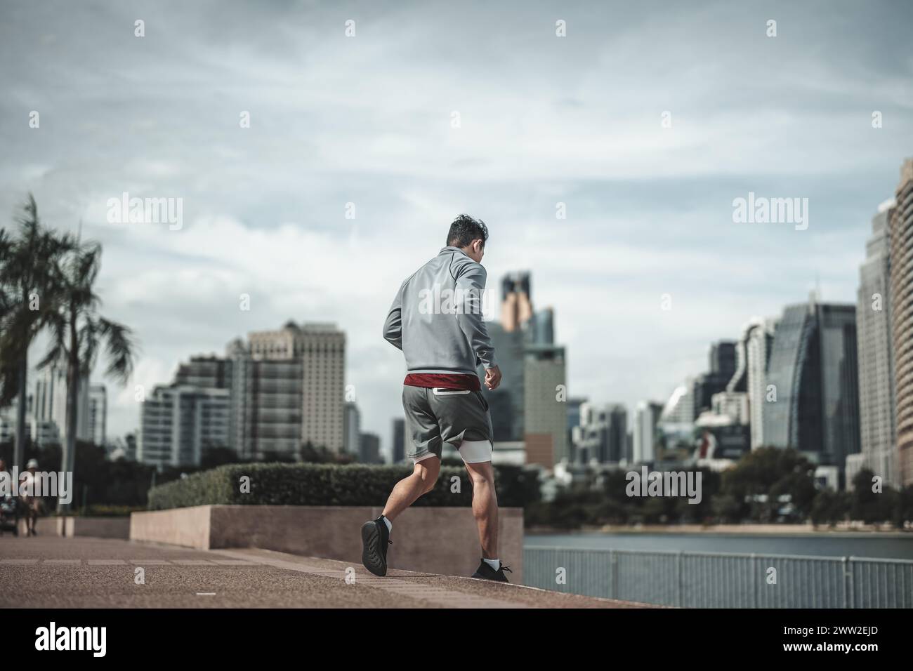 A man running down on stairs in the city center park before cardio ...