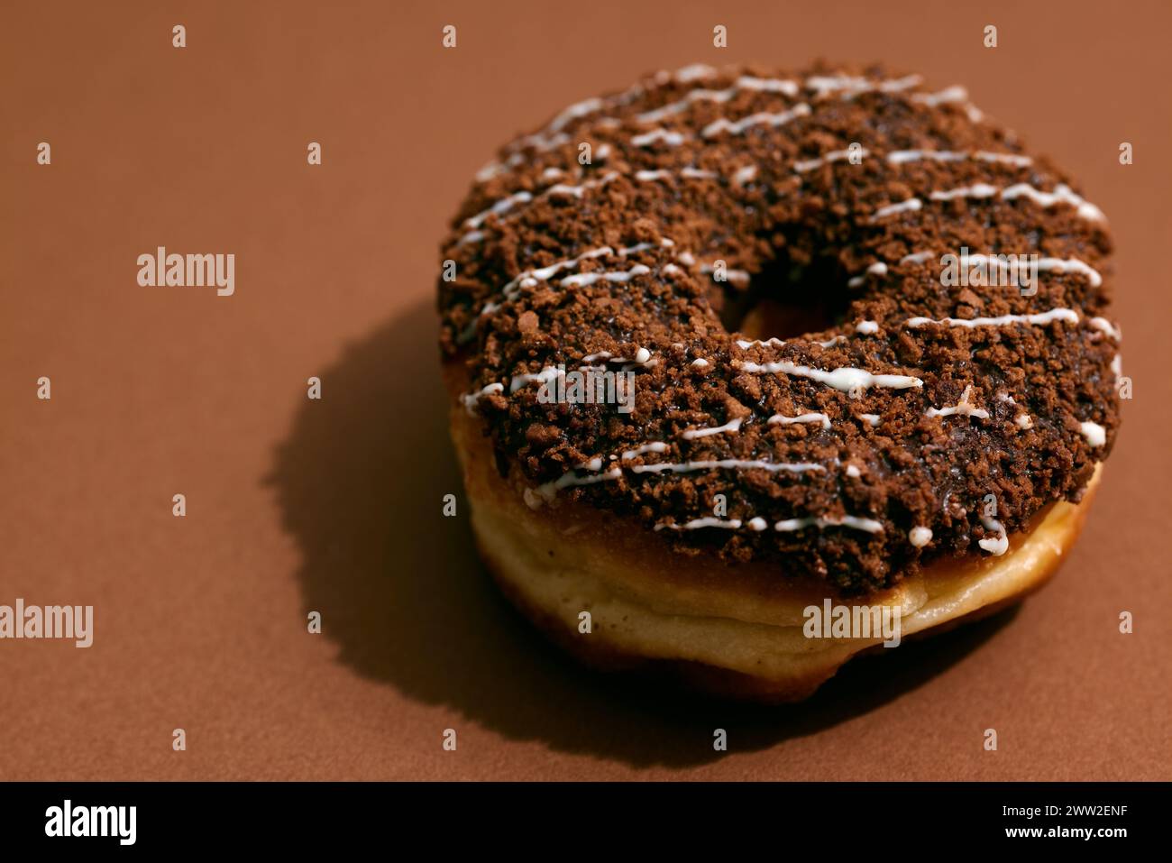 A chocolate covered doughnut sitting on a brown surface Stock Photo - Alamy