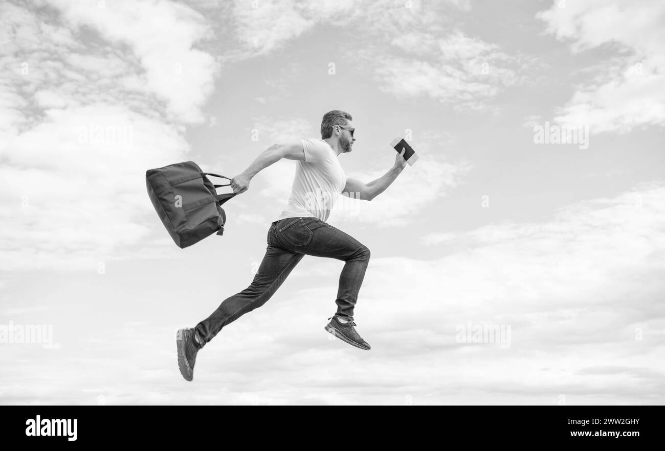 Energetic guy running with travel bag midair sky background, vacation ...