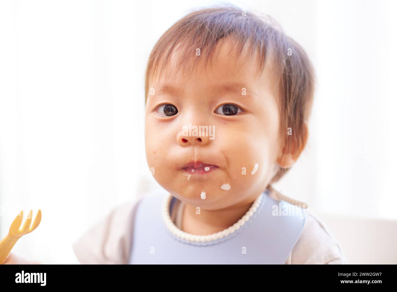 A baby eating with rice on his face Stock Photo - Alamy