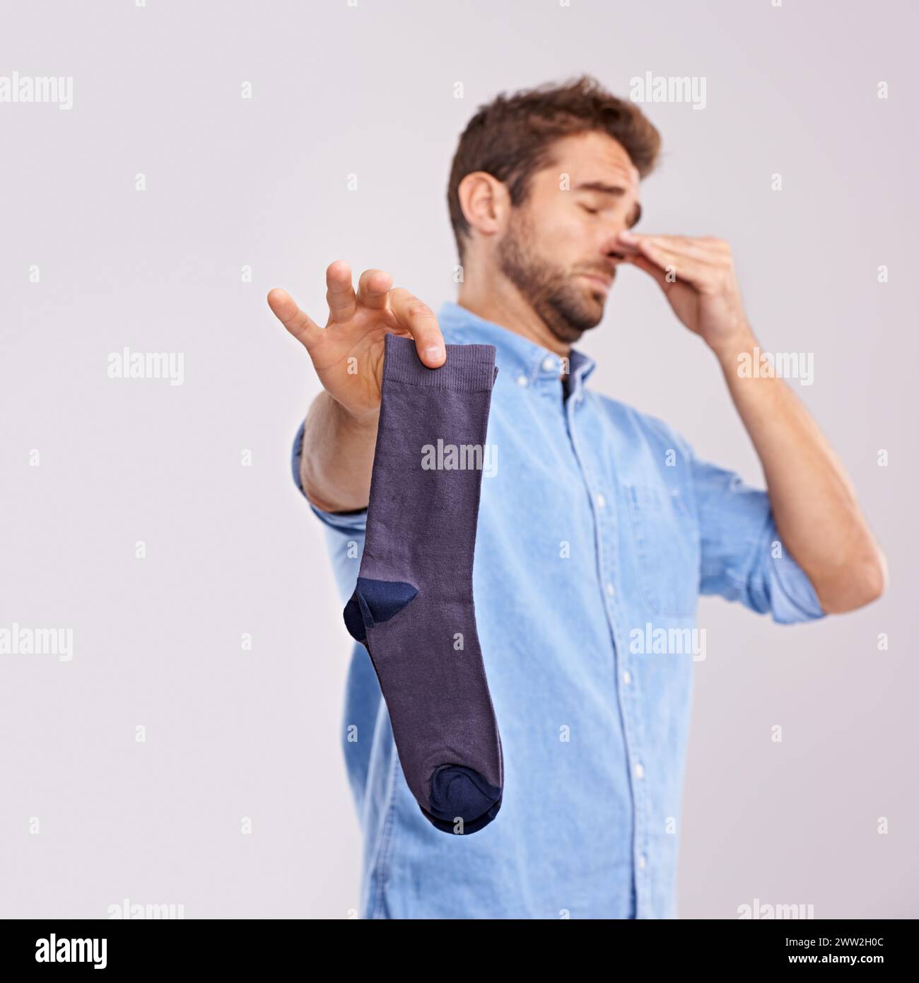 Man, smelly socks and close nose for poor hygiene with clothes, bad ...