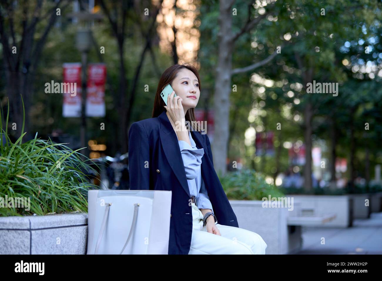 Women on bench holding phone hi-res stock photography and images - Alamy