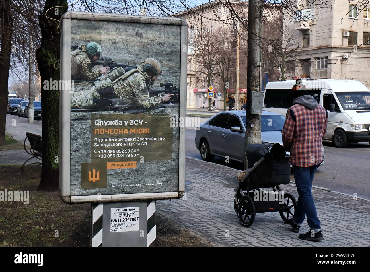 A man walks with a baby carriage past the recruitment poster for the ...