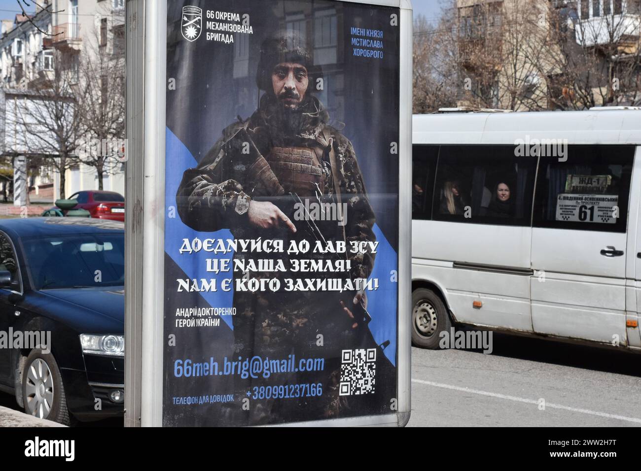 Women drive in a bus by the recruitment poster for the Ukrainian armed ...