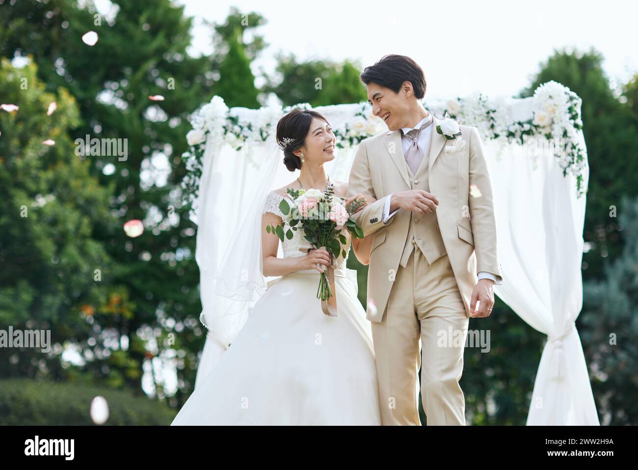A newly married couple standing under an arch Stock Photo - Alamy