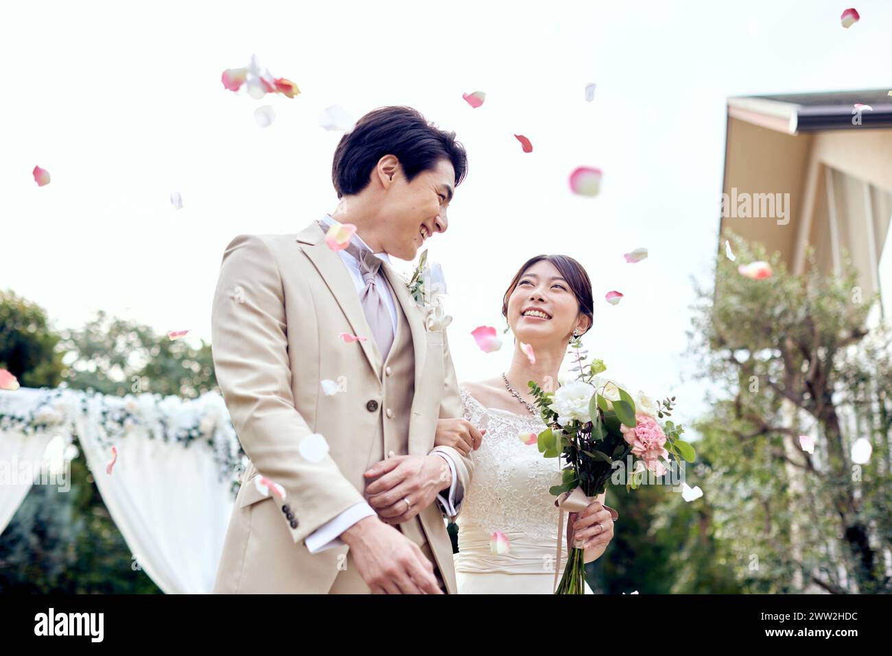 A newly married couple standing under a wedding arch Stock Photo - Alamy