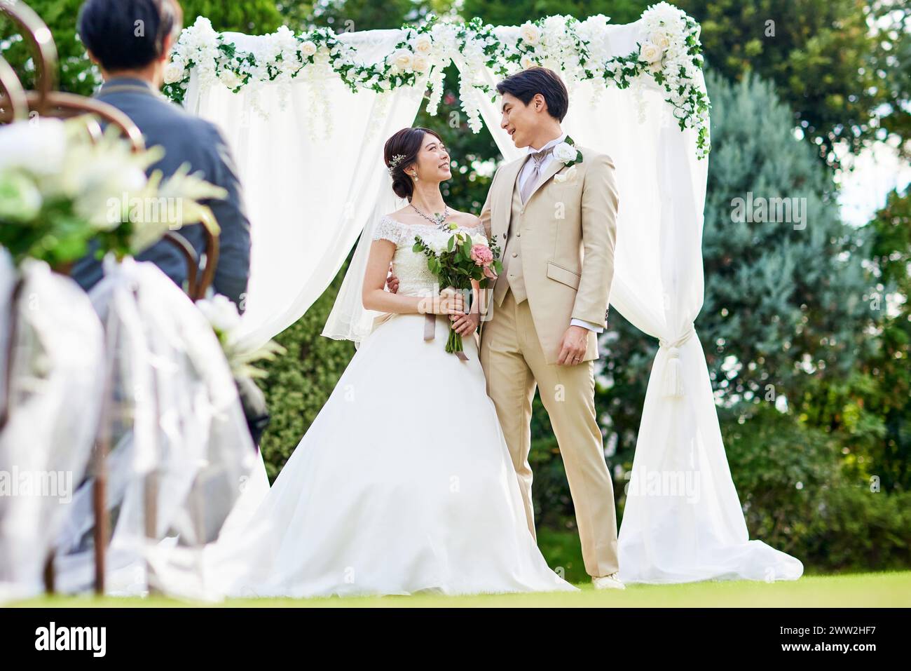 A newly married couple standing under a wedding arch Stock Photo - Alamy