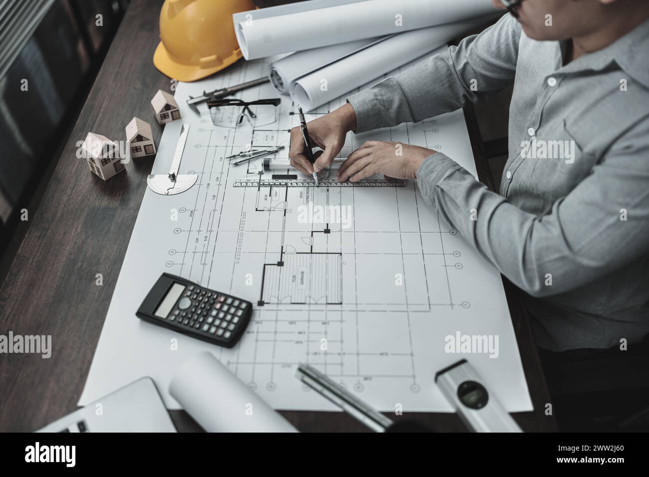 Architect engineer use pen and mini T-slide drawing design working on blueprint. House planning ...