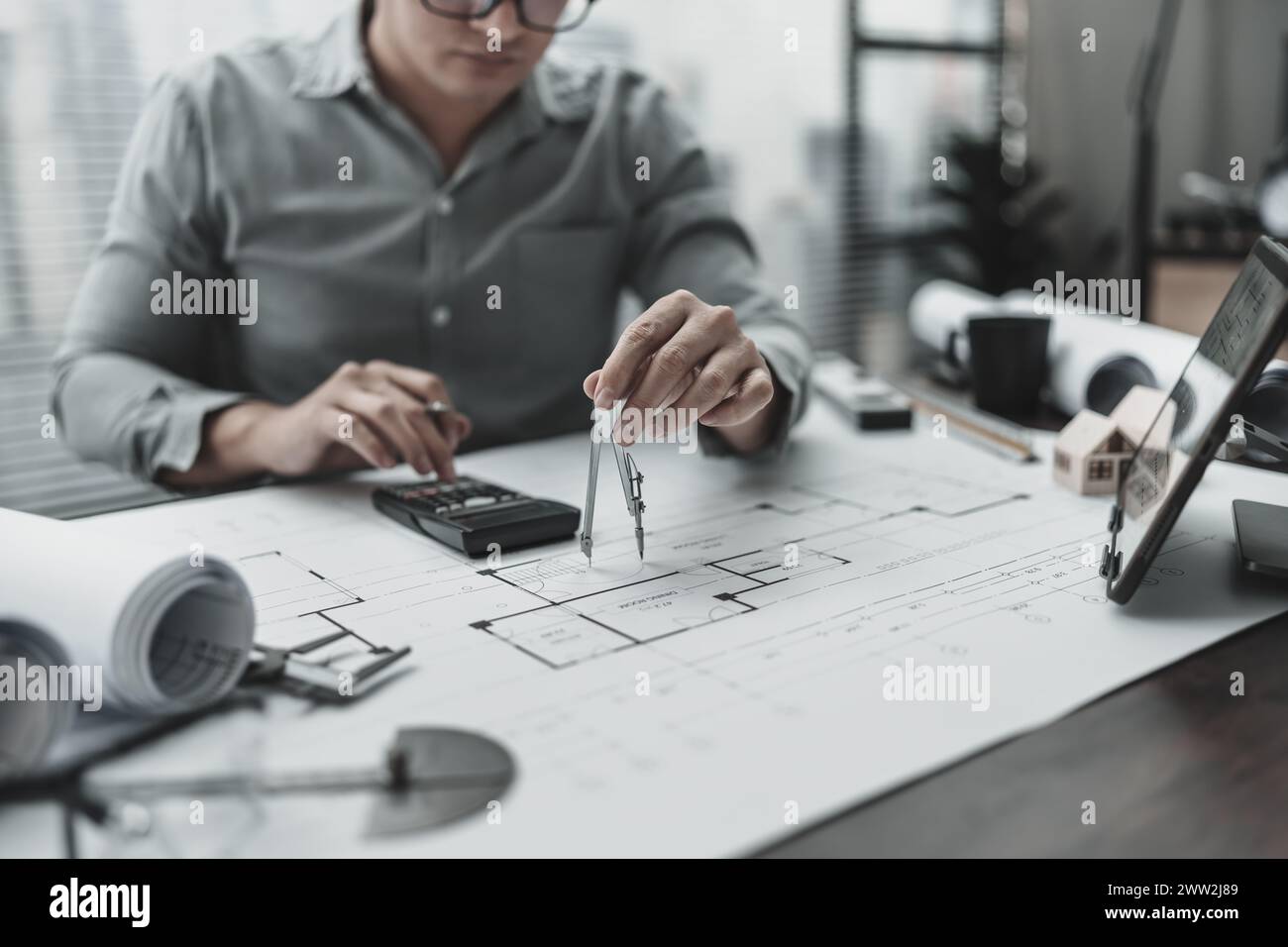 Architect using divider compass working on blueprint. House planning design and construction ...