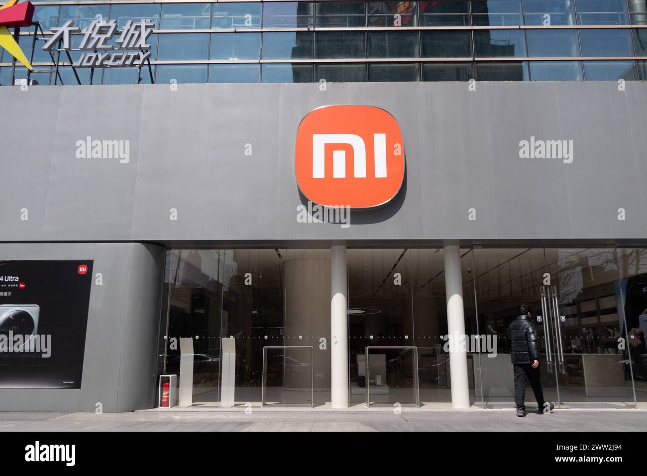 SHANGHAI, CHINA - MARCH 21, 2024 - Citizens walk past the a Xiaomi ...