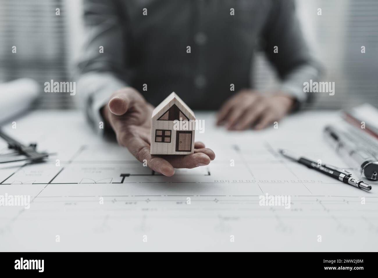 Architect engineer hands hold and protect mini house model on blueprint. Sell, Protect House ...