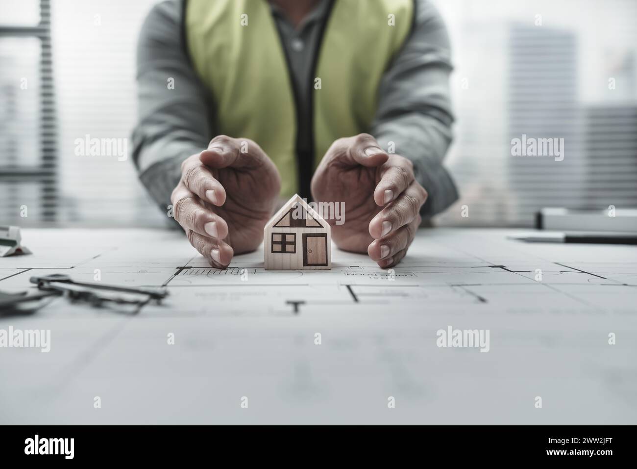 Architect engineer hands hold and protect mini house model on blueprint. Protect House, cost ...