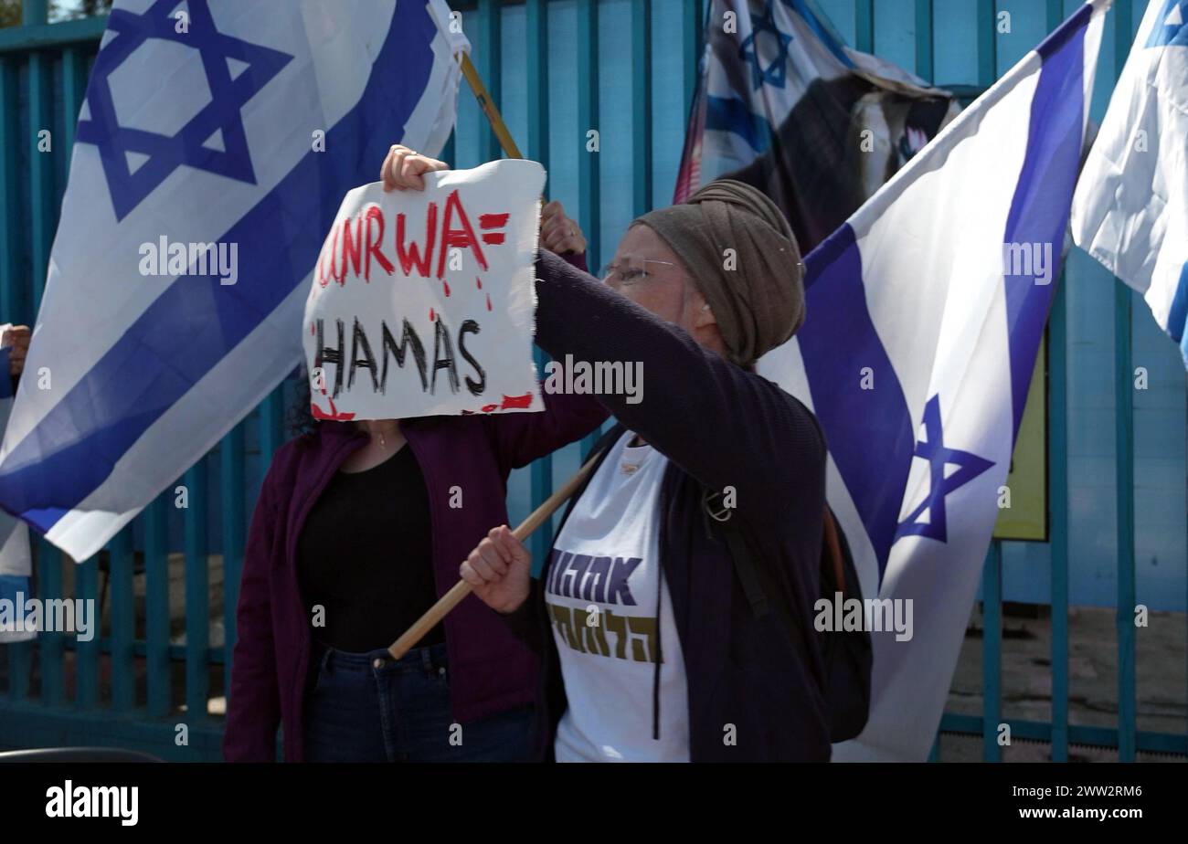 Right-wing activists hold signs that read "UNRWA equals Hamas" in front ...