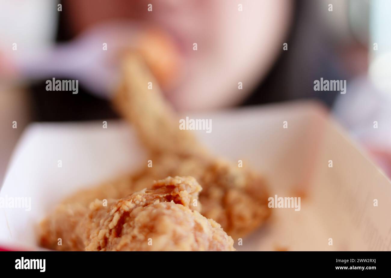 Woman eating fried chicken blurred background, Street food in thailand ...