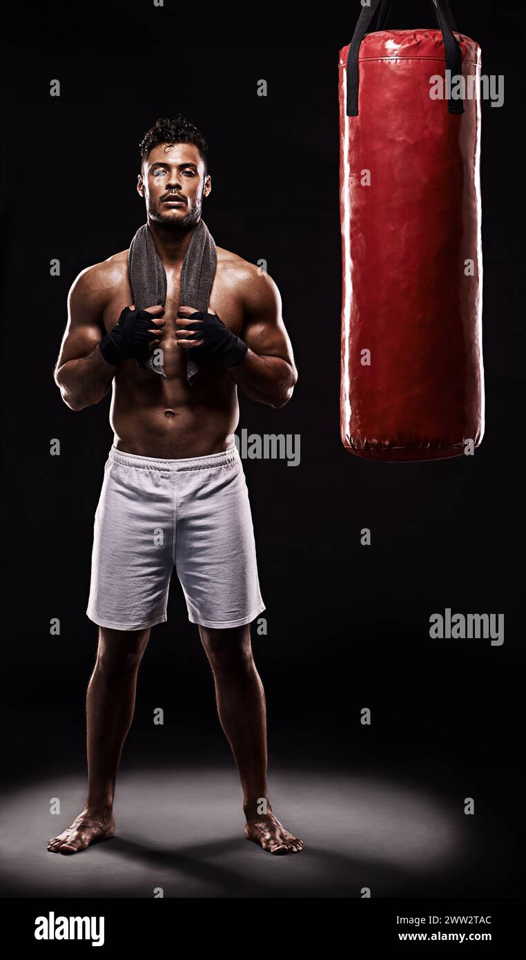 Portrait, boxing bag and male boxer for break, studio and athlete on ...