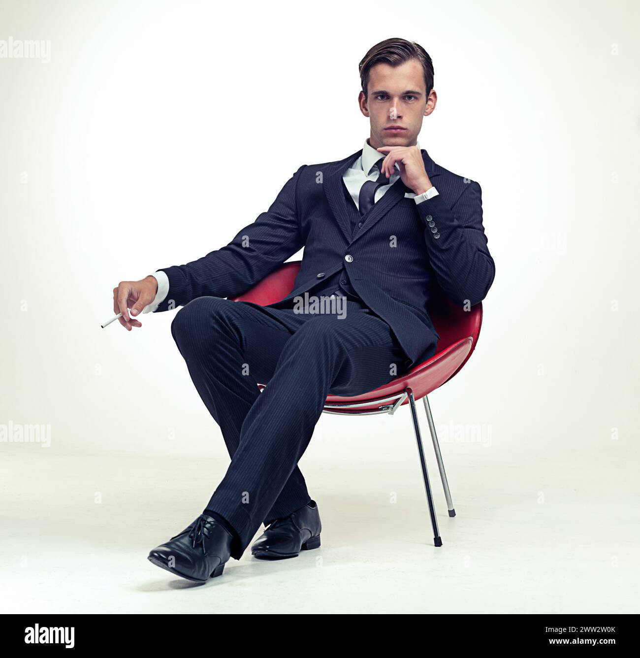 Suit, smoking and man portrait in chair, studio and serious in formal ...