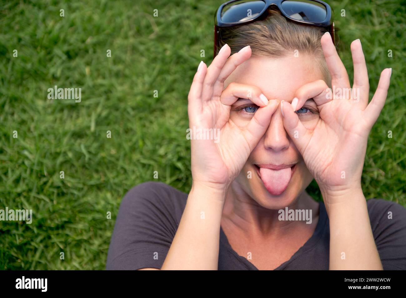 Portrait, hand glasses and woman with tongue out for funny face, goofy ...