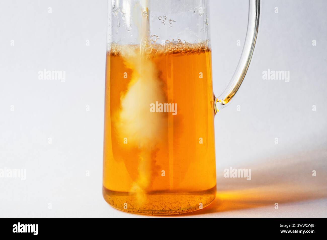 Pouring milk into big glass tea jug. English tea culture Stock Photo ...