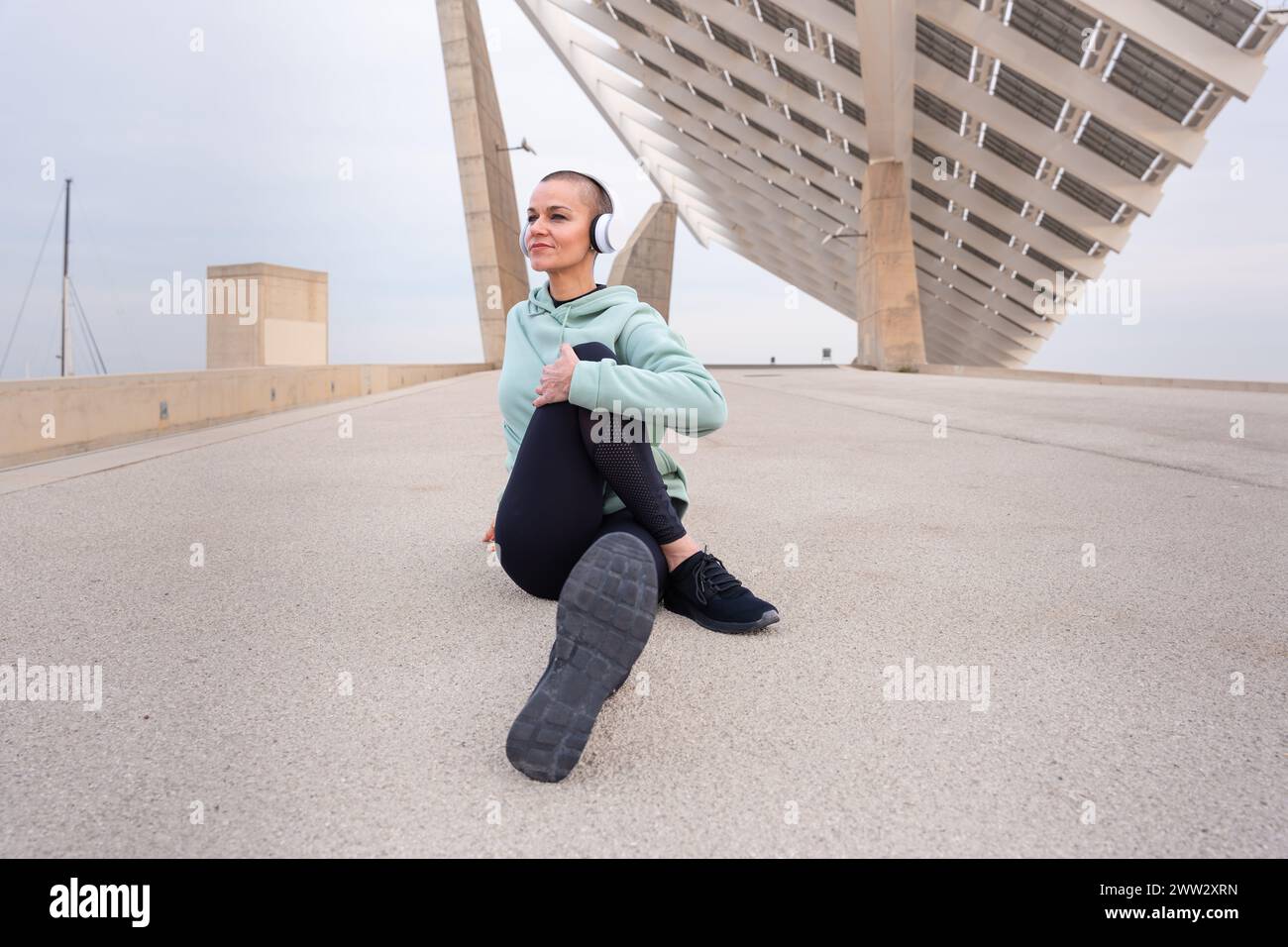 Active and fit female runner in warm-up stretching for running or ...