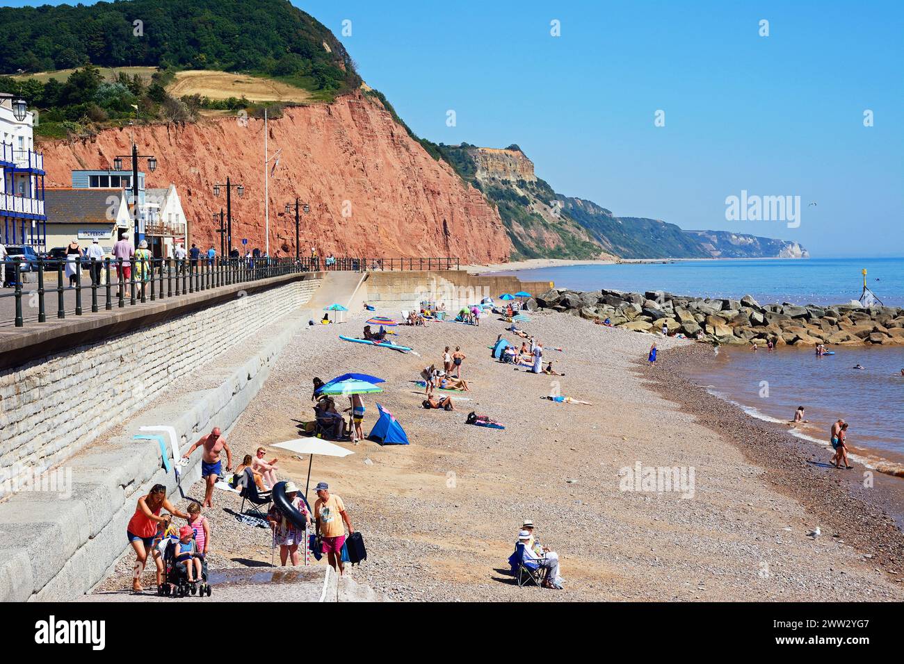 Tourists relaxing on the beach with Pennington Point cliffs to the rear ...